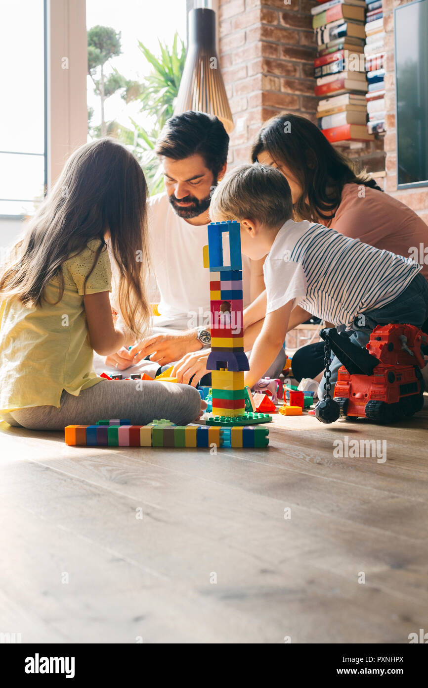 Family playing with building blocks on the floor together Stock Photo ...