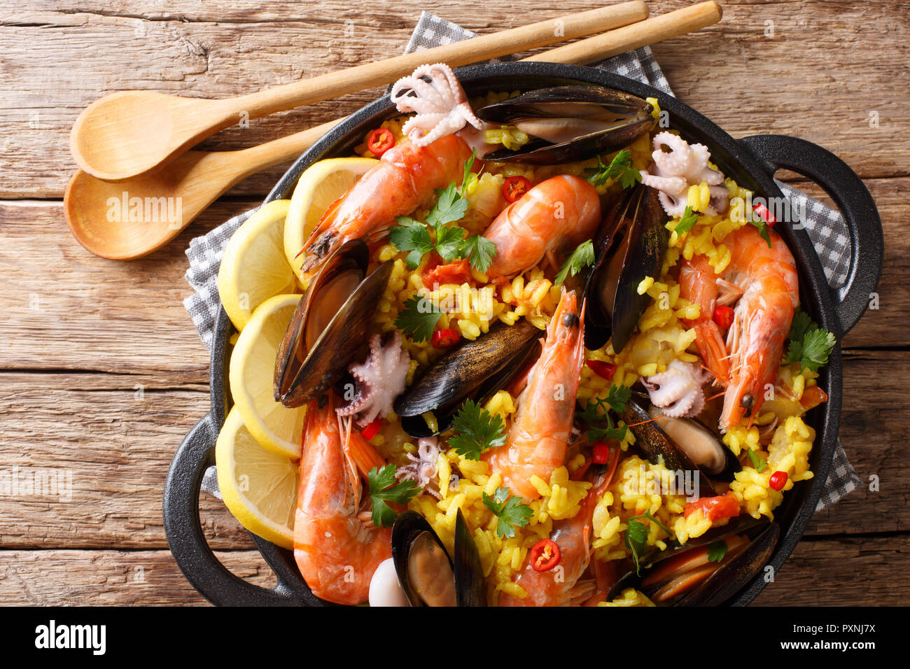 Spanish paella with shrimps, mussels, fish, and baby octopus close-up ...
