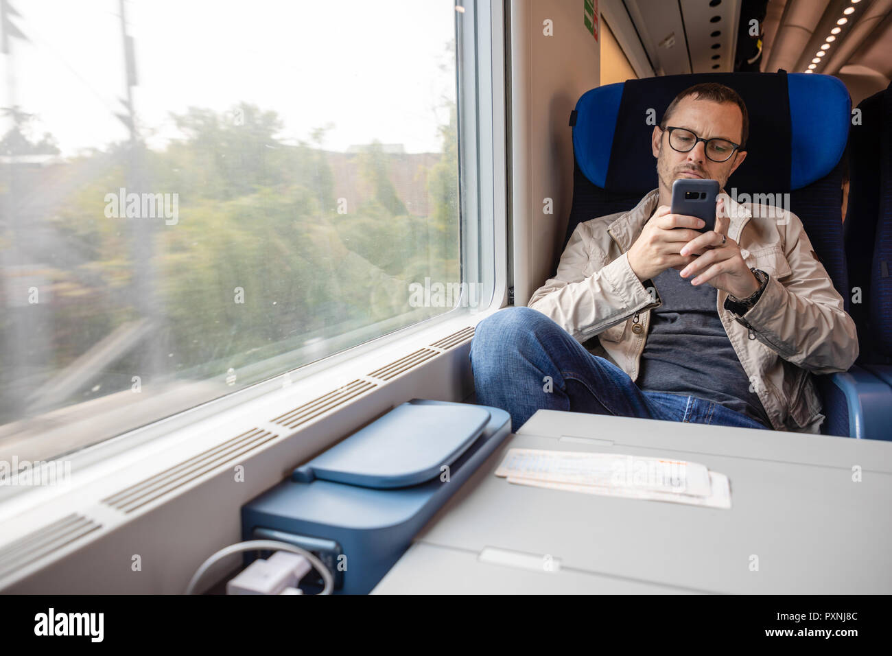 Middle age man looking out of the window of train. Passenger during ...