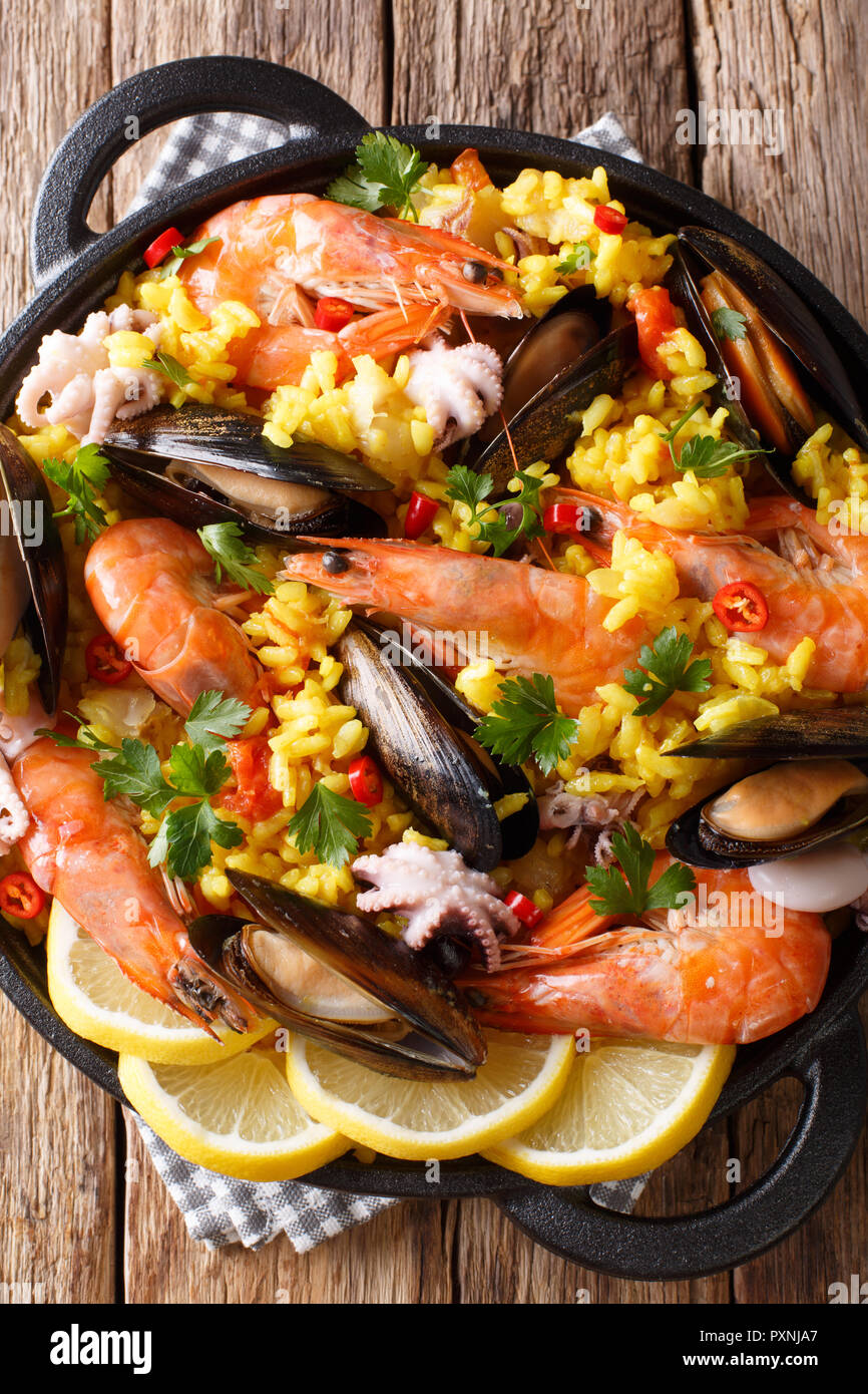 Spanish paella with shrimps, mussels, fish, and baby octopus close-up ...