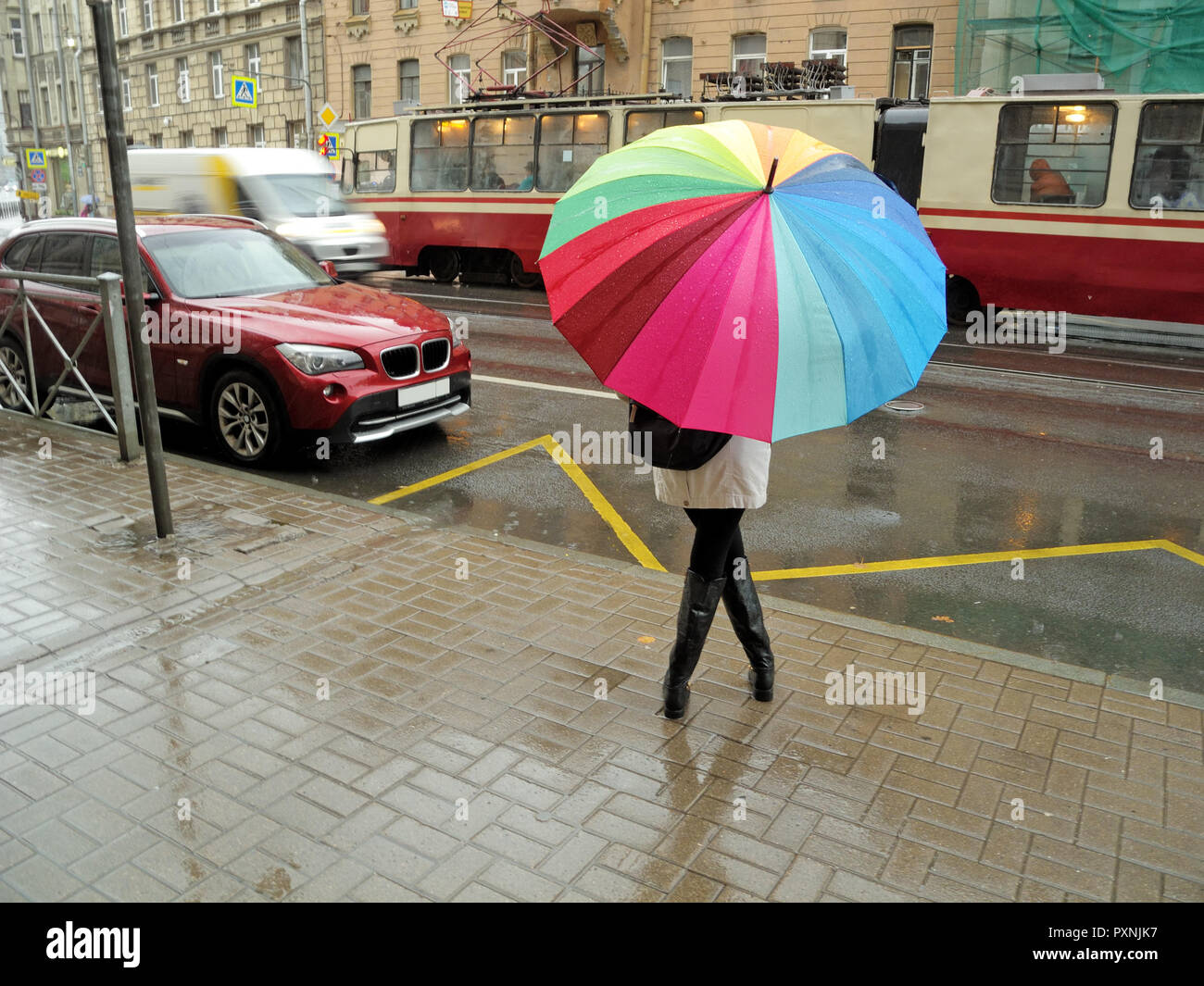 Girl hiding from the rain under an umbrella.She's waiting at the bus ...