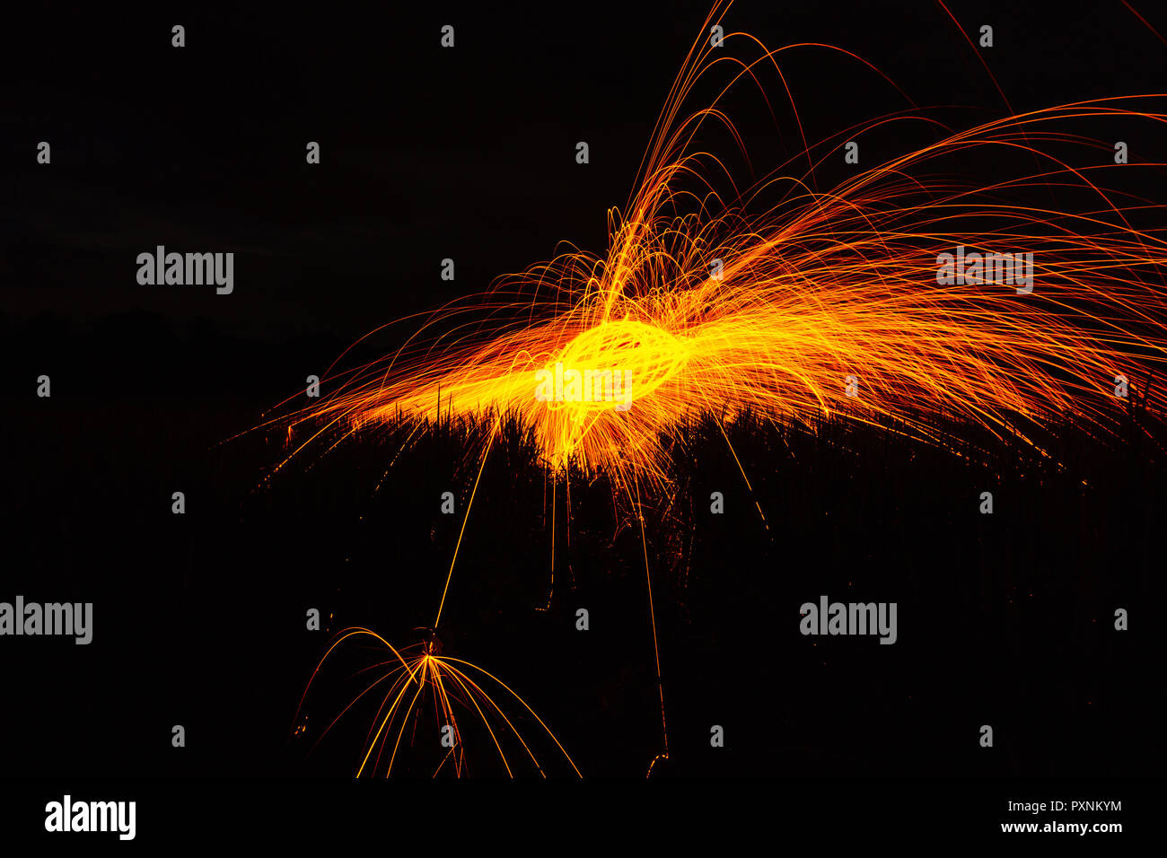 Burning steel wool spinned in the forest. Showers of glowing sparks ...