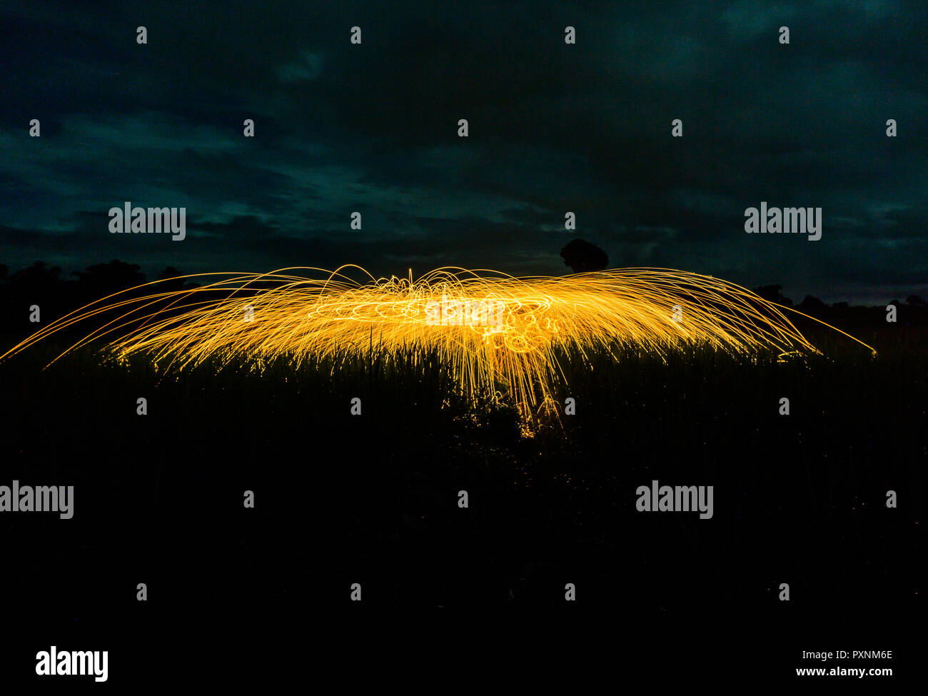 Burning steel wool spinned in the forest. Showers of glowing sparks ...