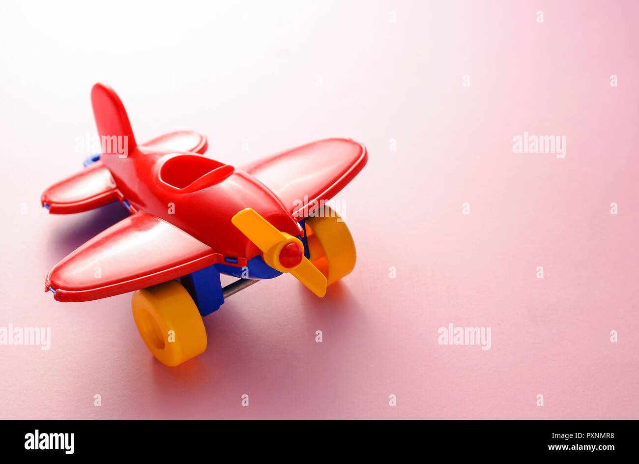 Children's toy red plane on a pink gradient background Stock Photo - Alamy