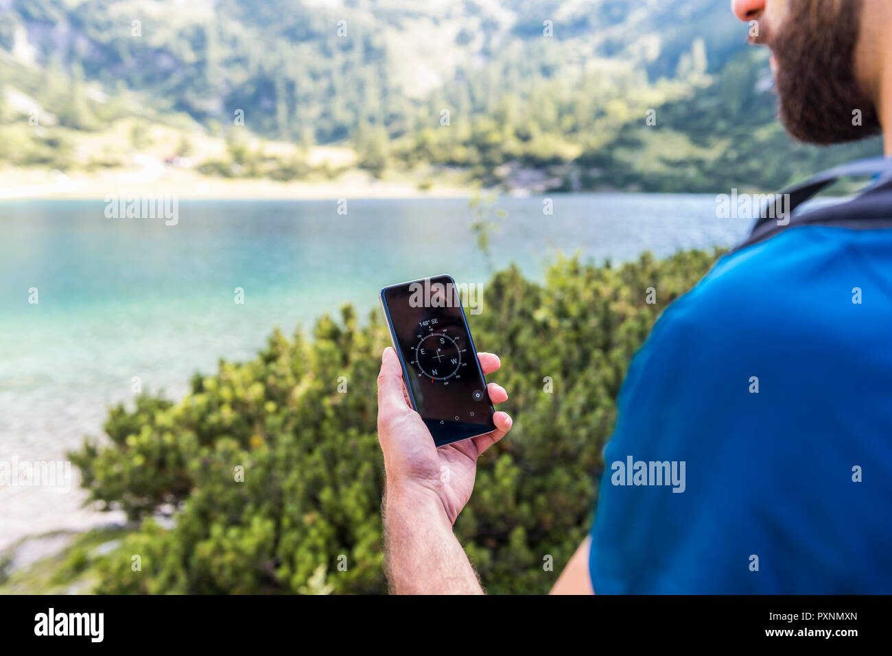 Austria, Tyrol, Hiker using compass app at Lake Seebensee Stock Photo ...
