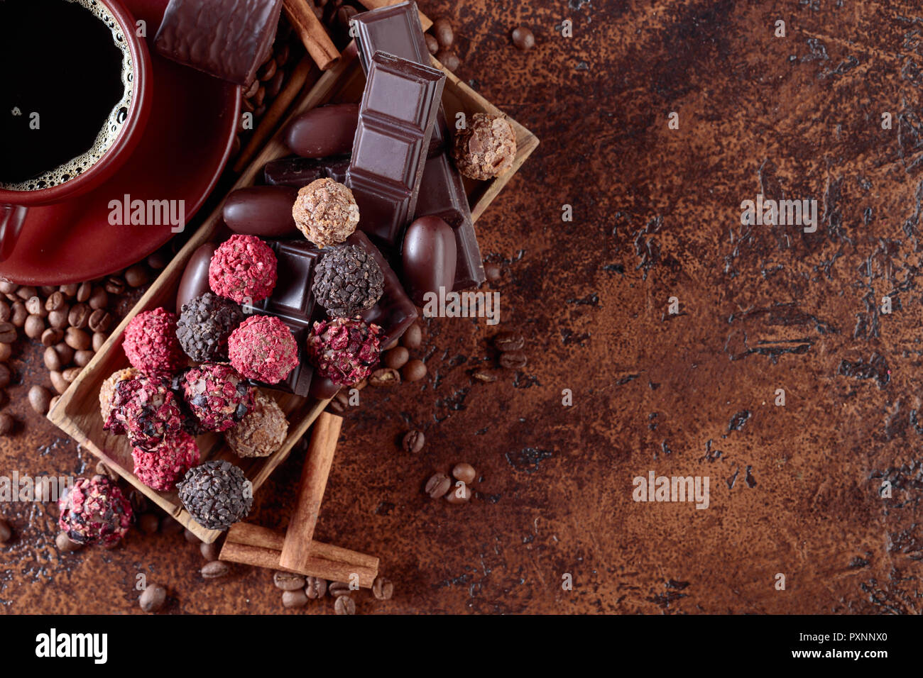Various chocolates and cup of black coffee. Sweets with cinnamon sticks ...