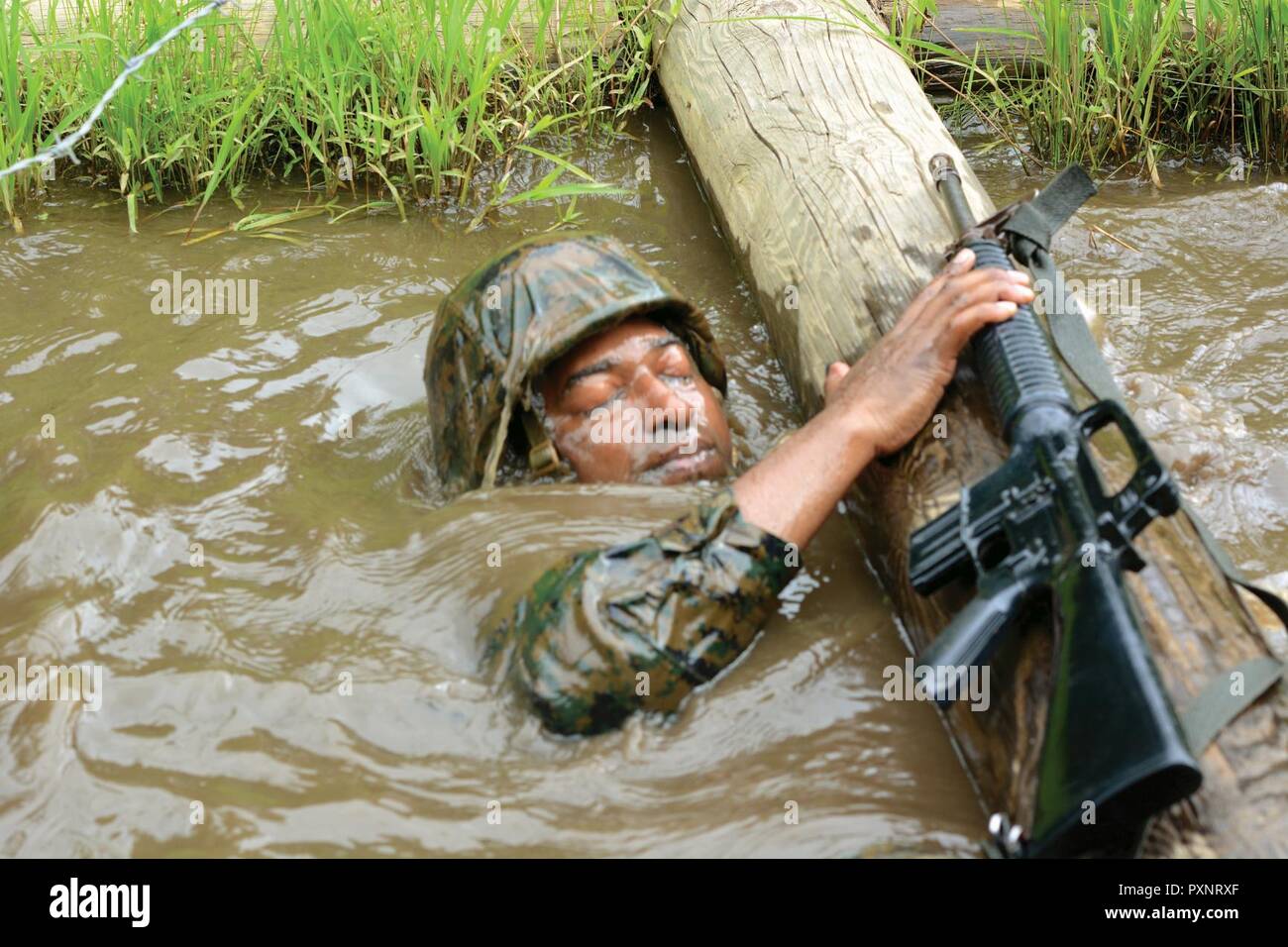 A Marine navigates a log obstacle along "The Quigley" in honor of the ...