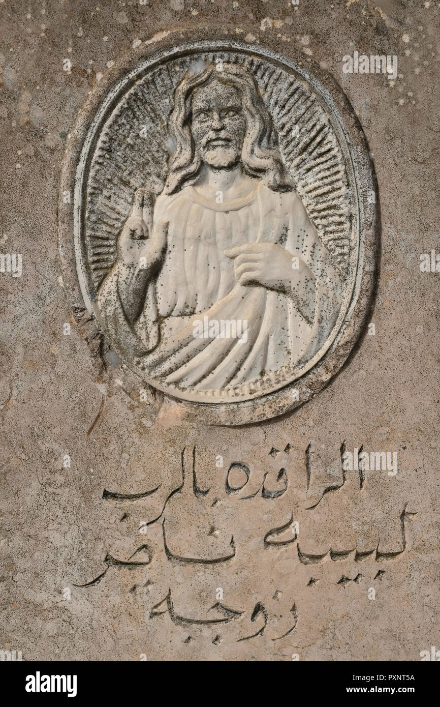 Old stone headstone shows carved image of Jesus with his right hand ...