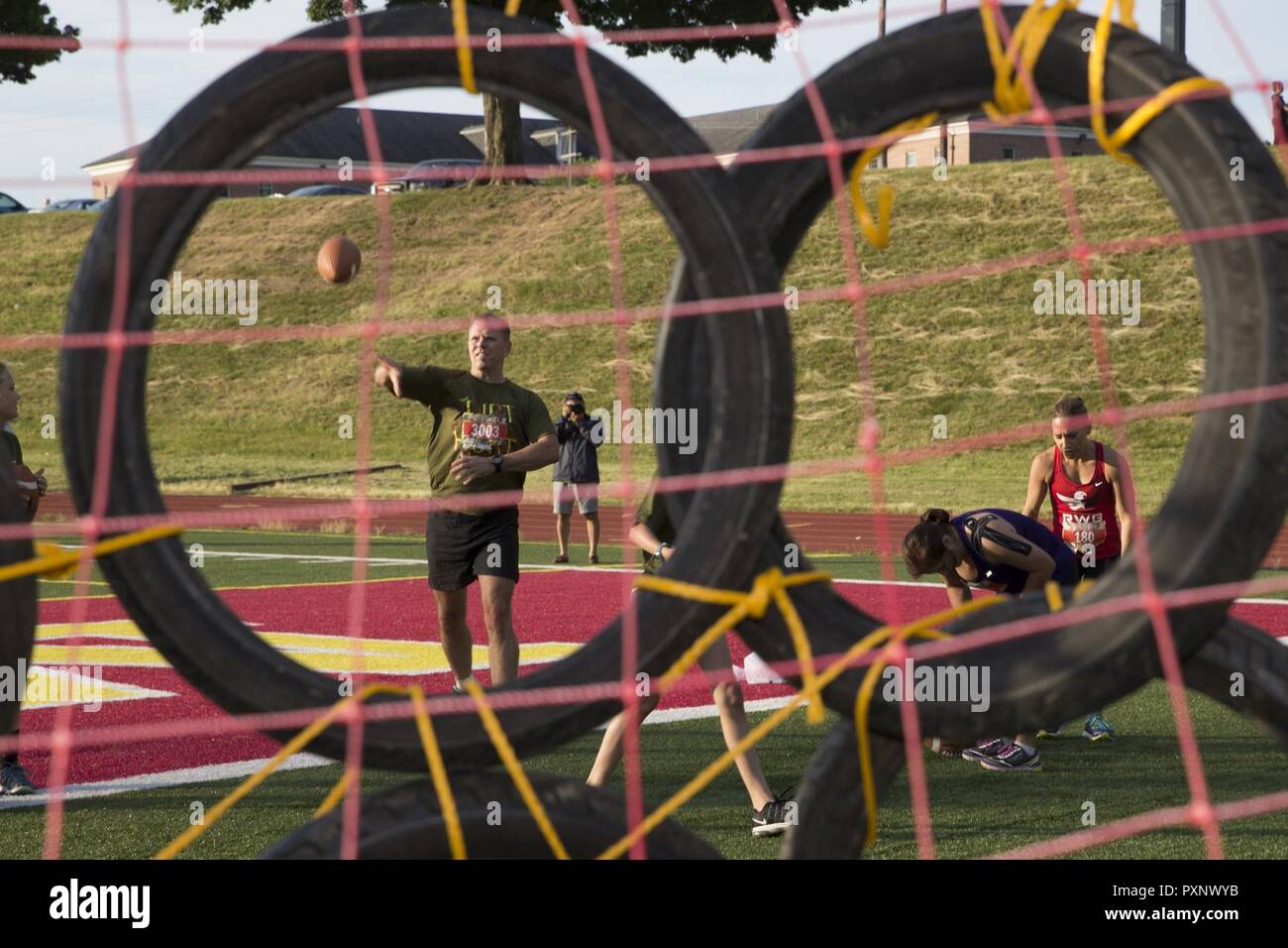 A participant throws a football during the annual Marine Corps Marathon ...