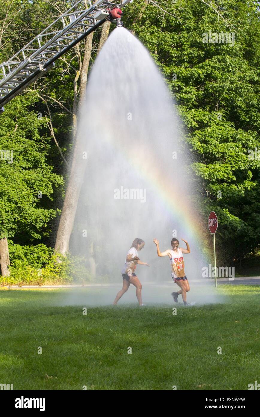 Participants run through a water hose during the annual Marine Corps ...