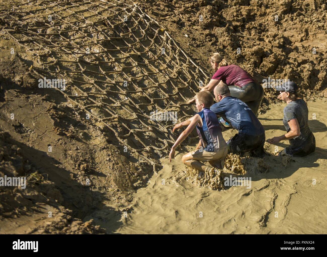 Participants maneuver through a mud pit during the annual Marine Corps ...
