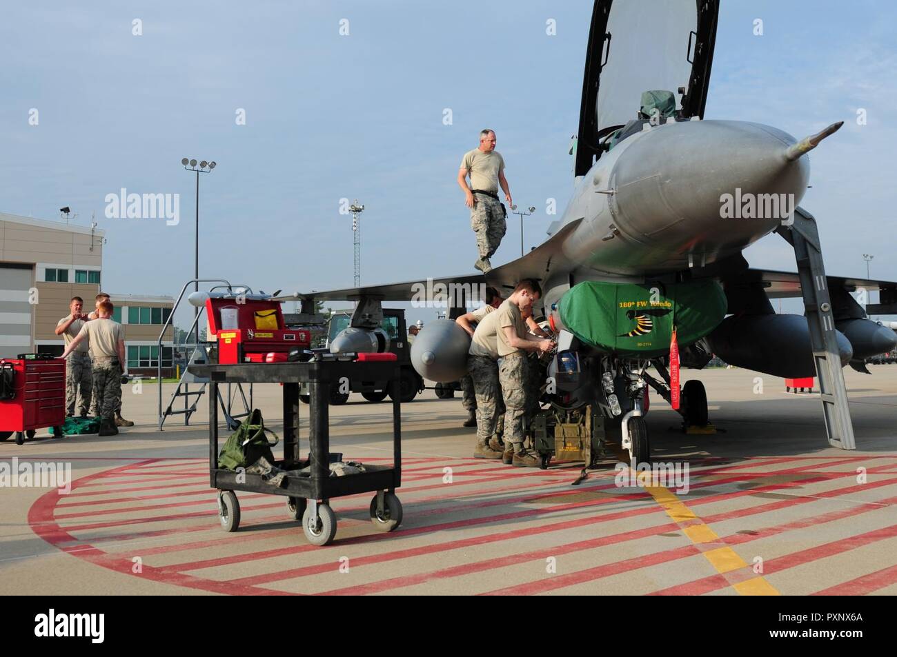 Airmen work on an F-16 Fighting Falcon on the flightline June 14, 2017 ...