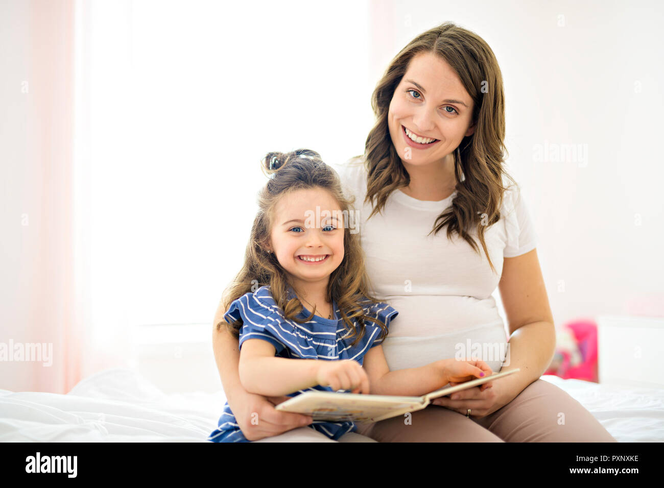 Portrait Of A Mother And Daughter Reading A Book Lying And Relax In The
