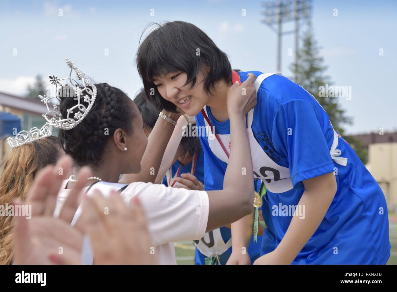 An athlete receives a gold medal from Lesley Ortiz, Mrs.Sakura 2017 ...