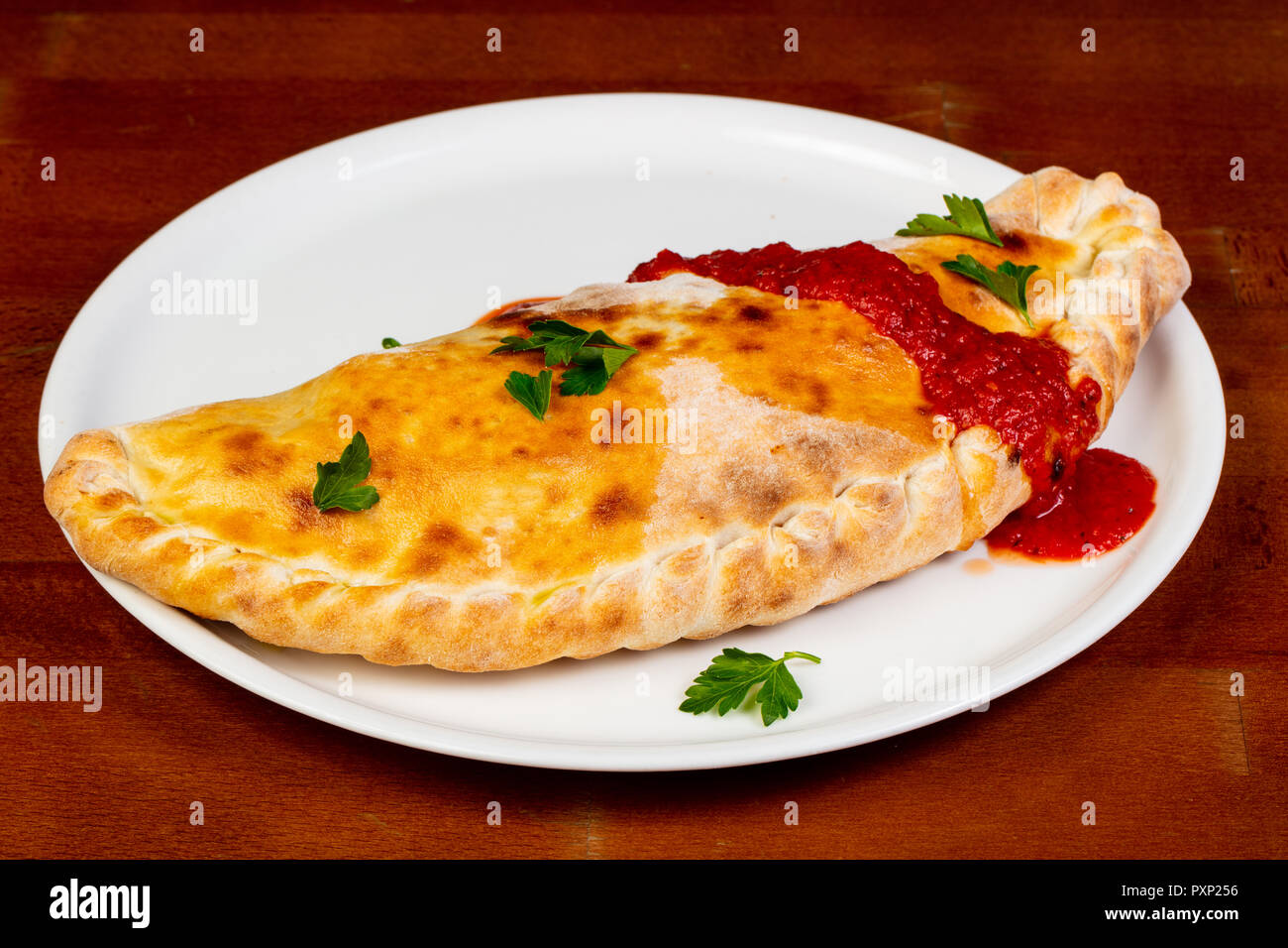 Closed Calzone pizza with meat and cheese Stock Photo - Alamy