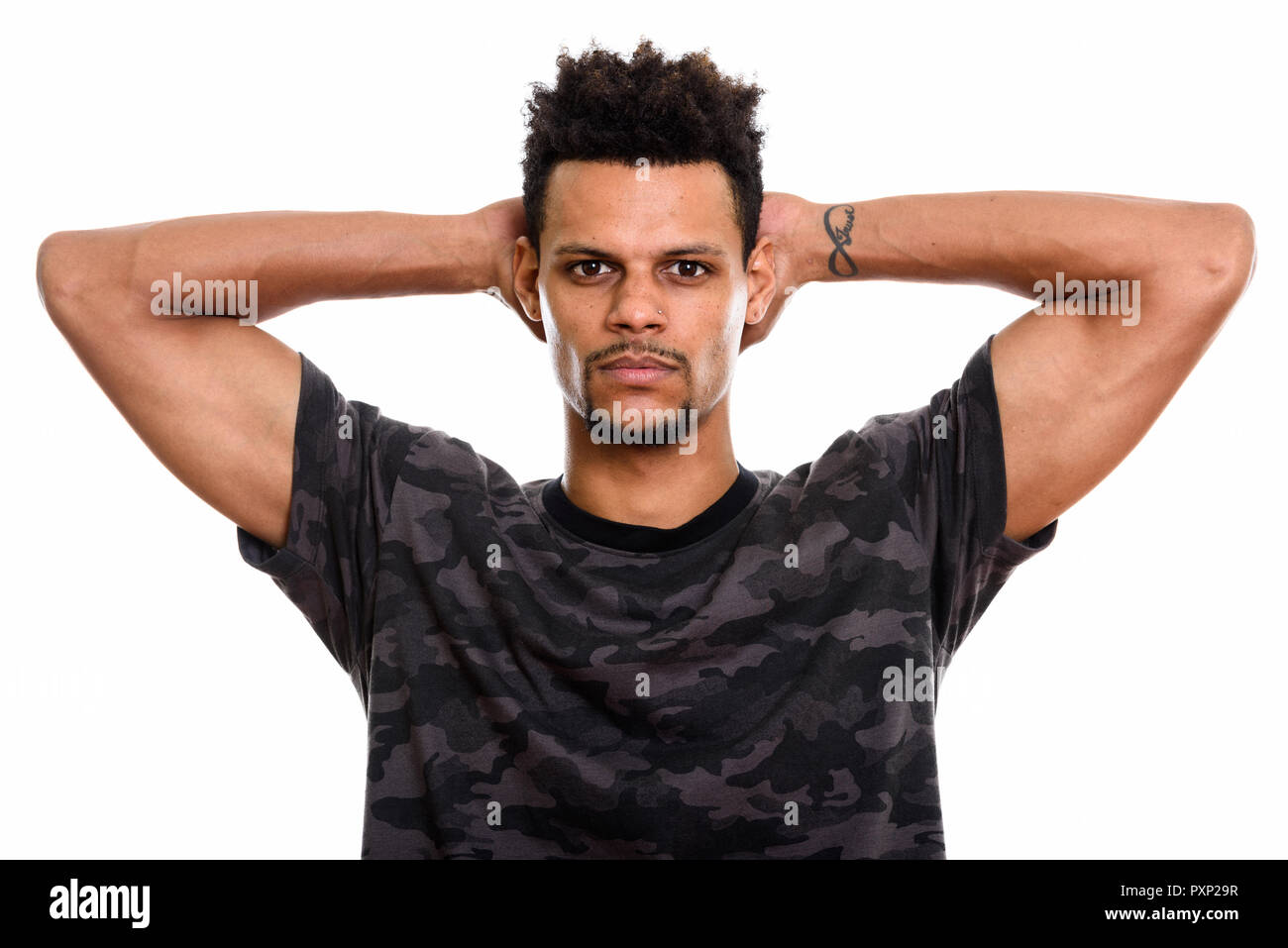 Studio shot of young African man with both hands behind back of Stock ...
