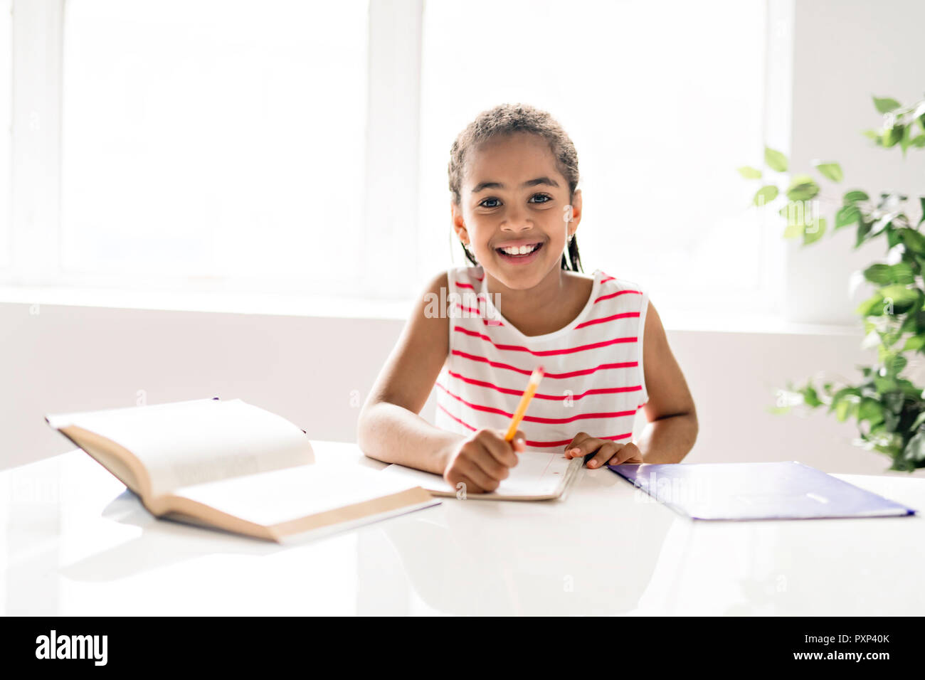 A cute Black girl doing homework at home Stock Photo - Alamy