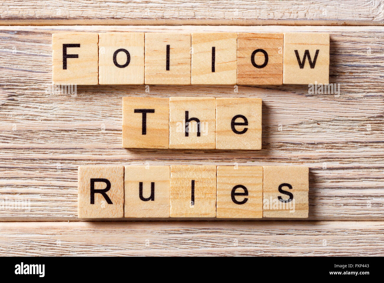 Follow The Rules word written on wood block. Follow The Rules text on ...