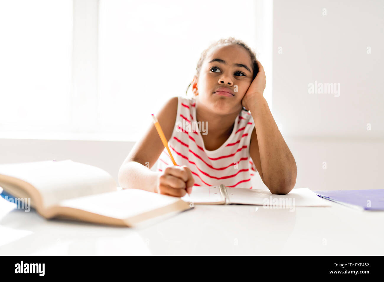A cute Black girl doing homework at home Stock Photo - Alamy