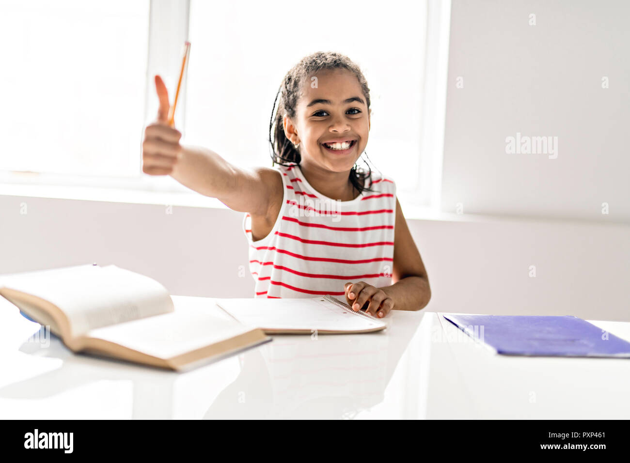 A cute Black girl doing homework at home Stock Photo - Alamy
