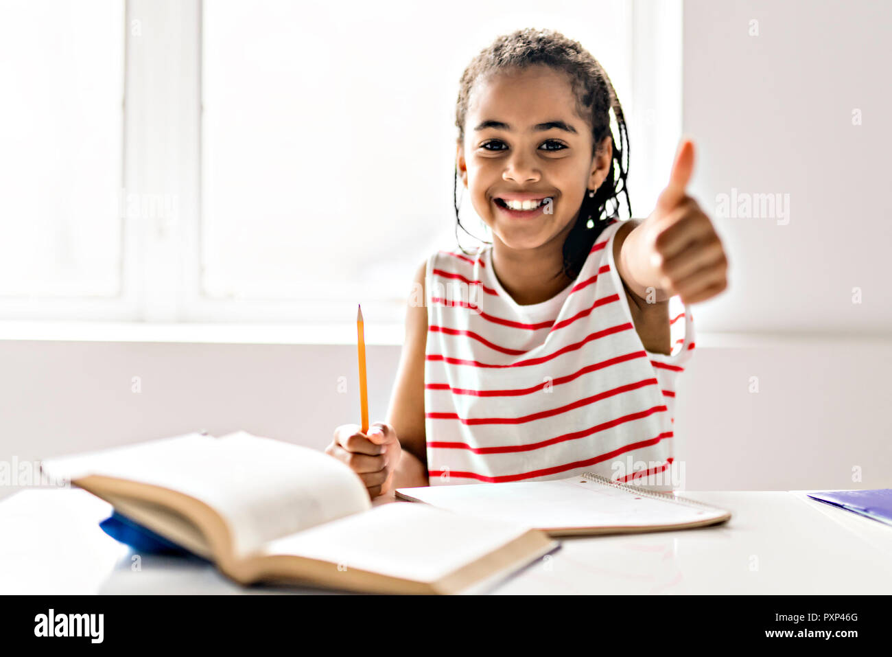 A cute Black girl doing homework at home Stock Photo - Alamy
