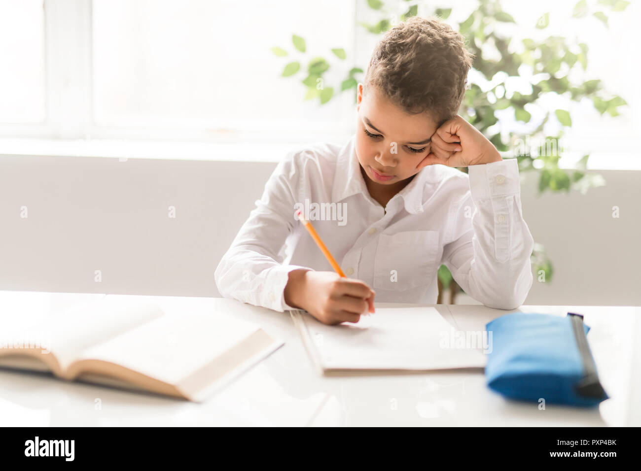 A cute Black boy doing homework at home Stock Photo - Alamy