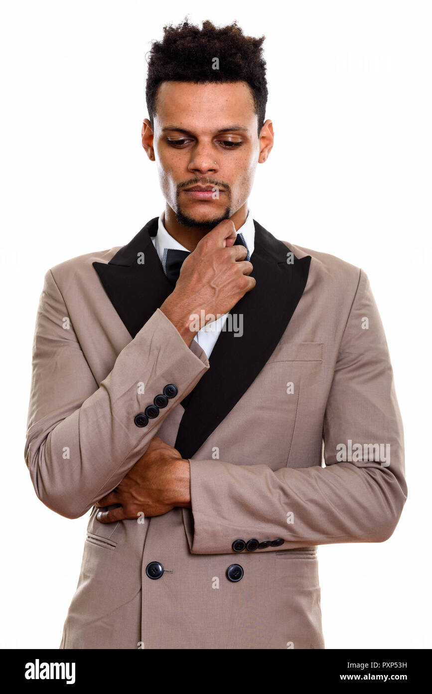 Studio shot of young African businessman thinking while looking Stock ...