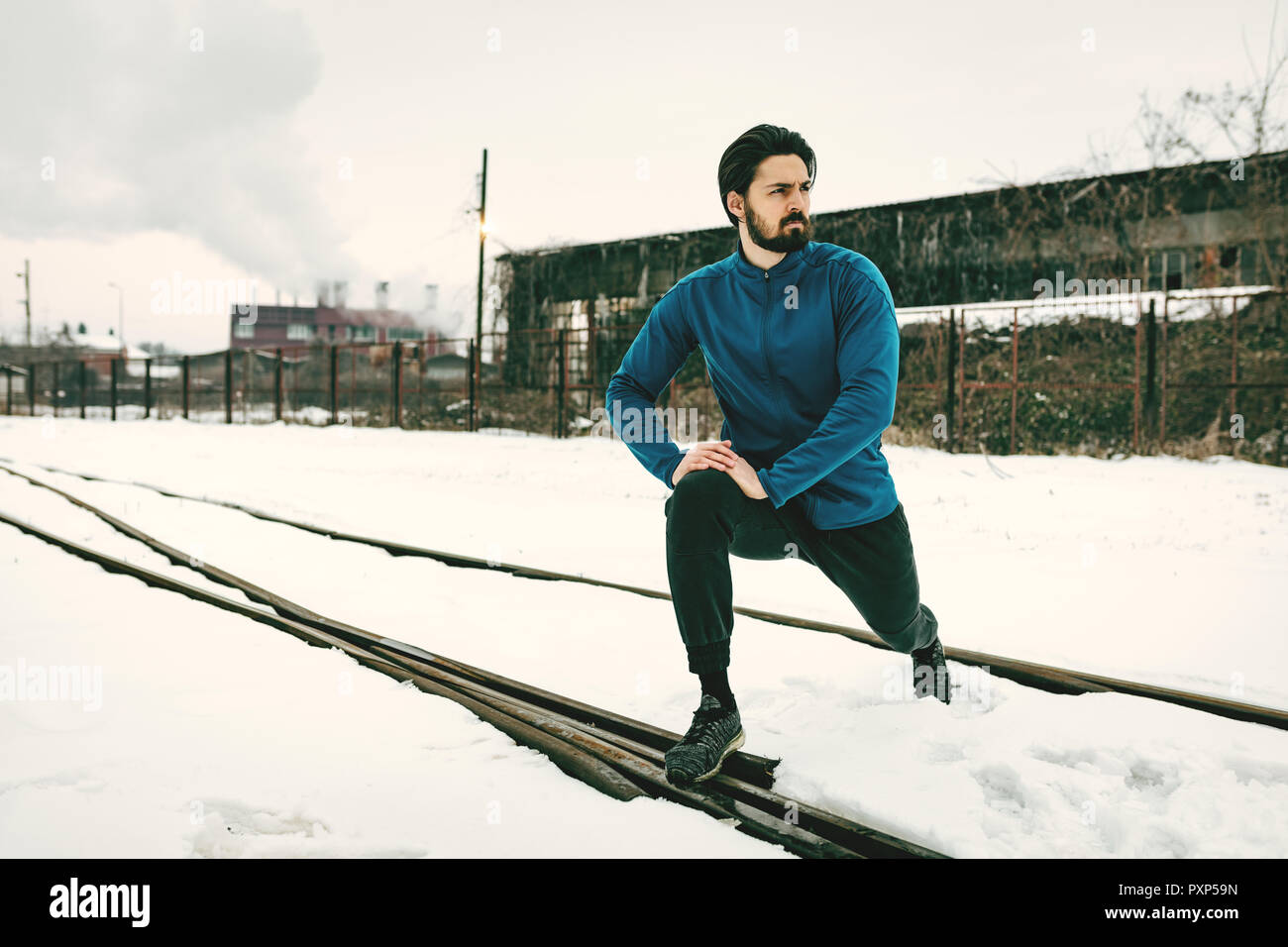 Active young man stretching and doing exercises in the public place ...