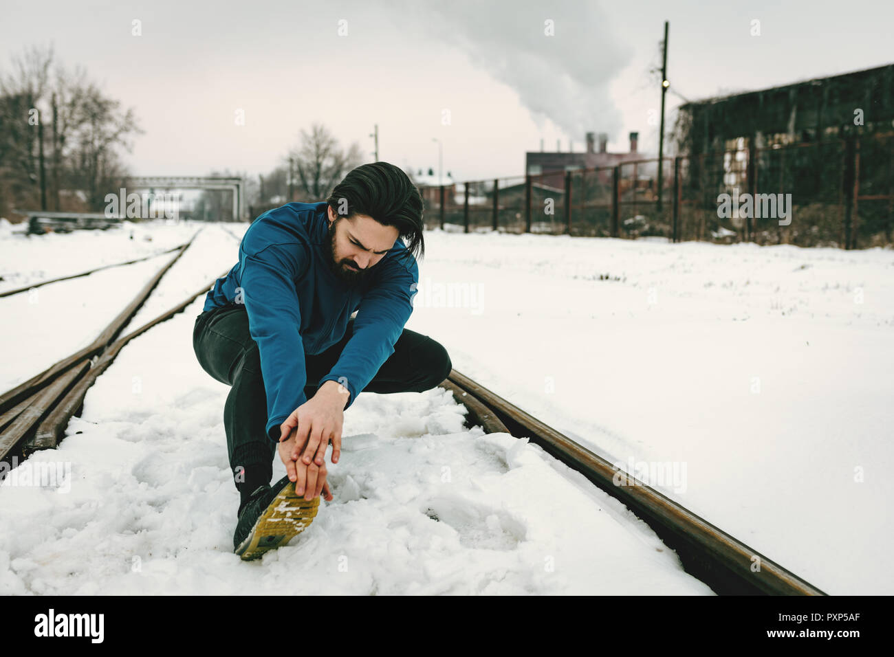 Active young man stretching and doing exercises in the public place ...