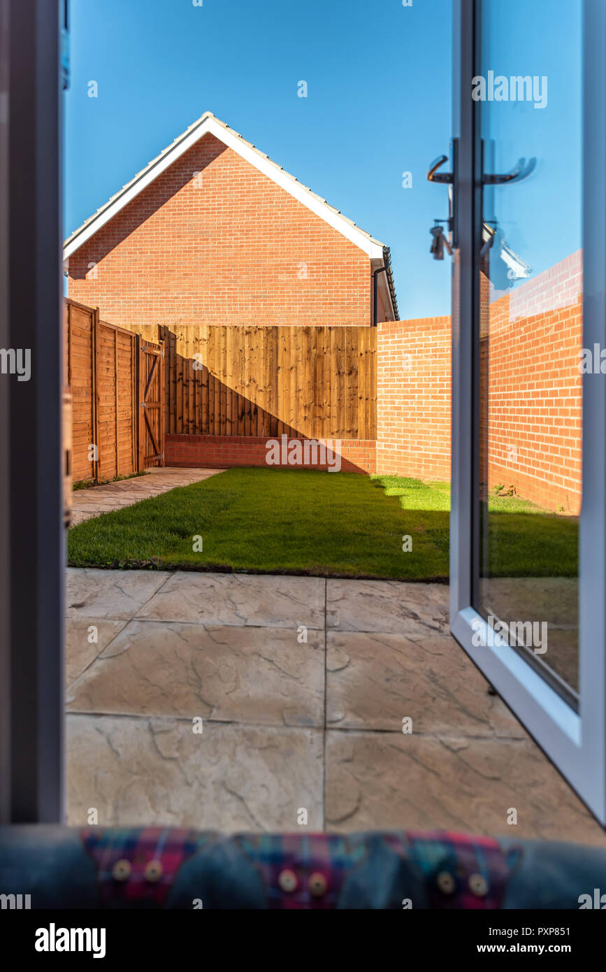 day view of new home garden through open door of British housing ...