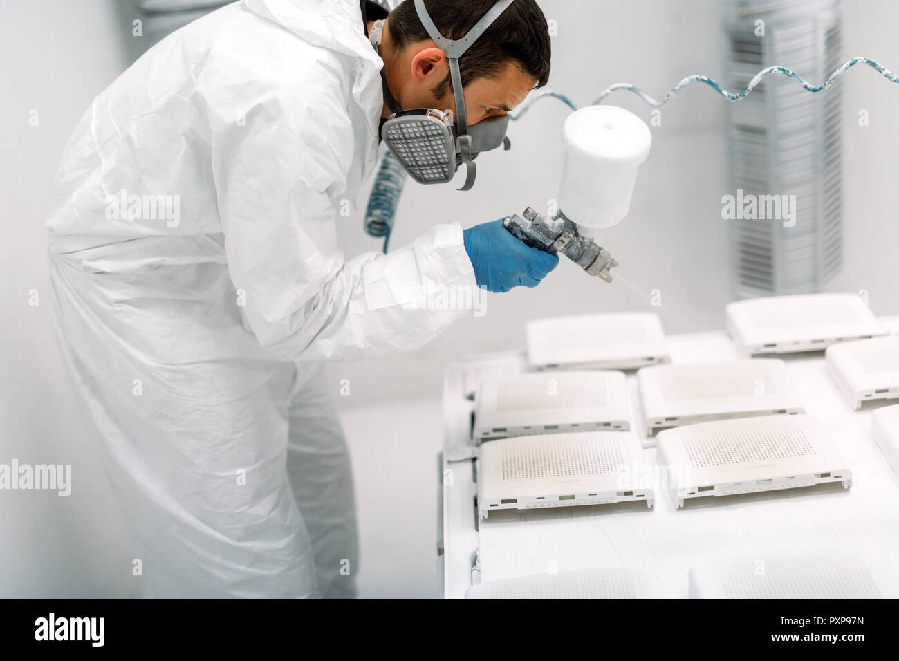 Painter using airbrush to paint wearing protective clothing Stock Photo ...