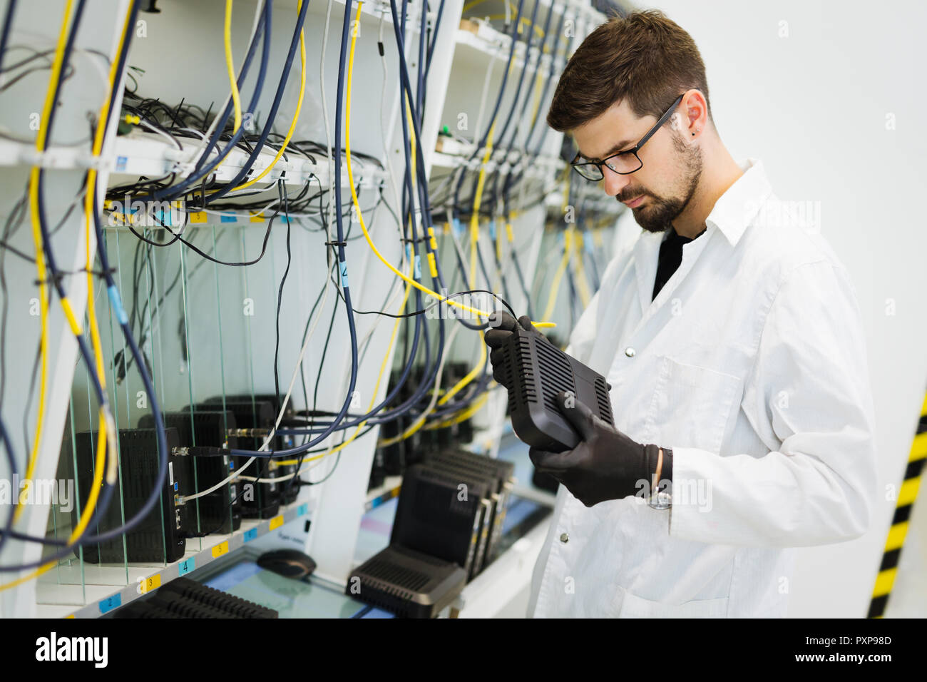 Picture of network technician testing modems in factory Stock Photo - Alamy