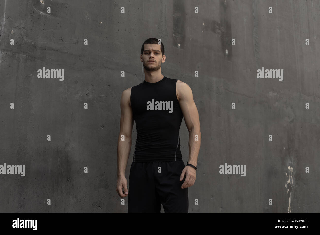 Portrait of athletic muscular young man, in sports clothing, posing on ...