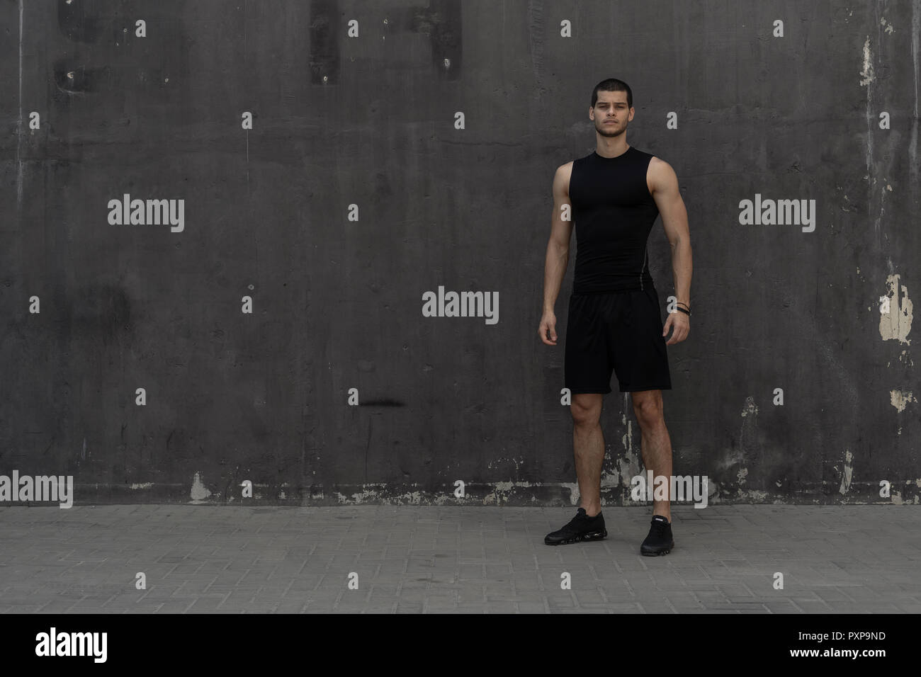 Portrait of athletic muscular young man, in sports clothing, posing on ...