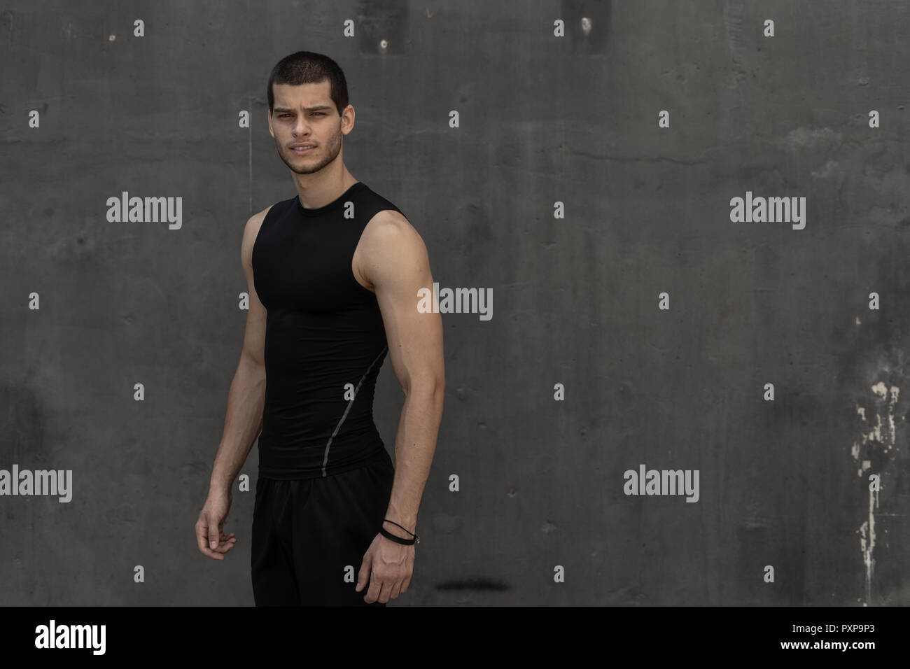 Portrait of athletic muscular young man, in sports clothing, posing on ...