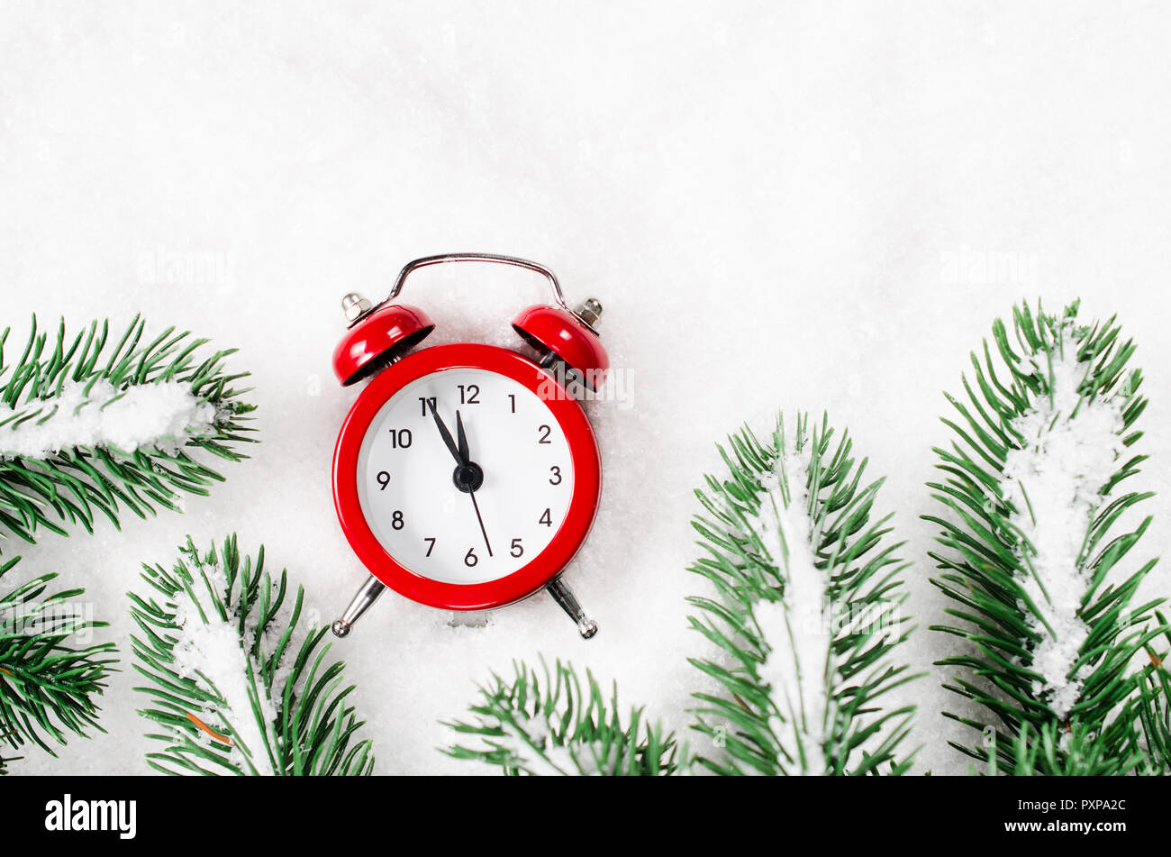 Christmas Eve and New Years clock at midnight with snow-covered fir ...