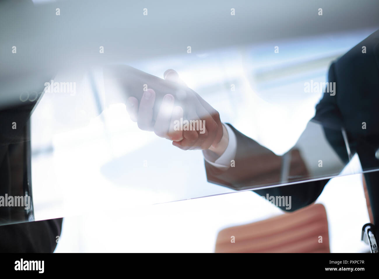business background. handshake of business partners above the Desk ...