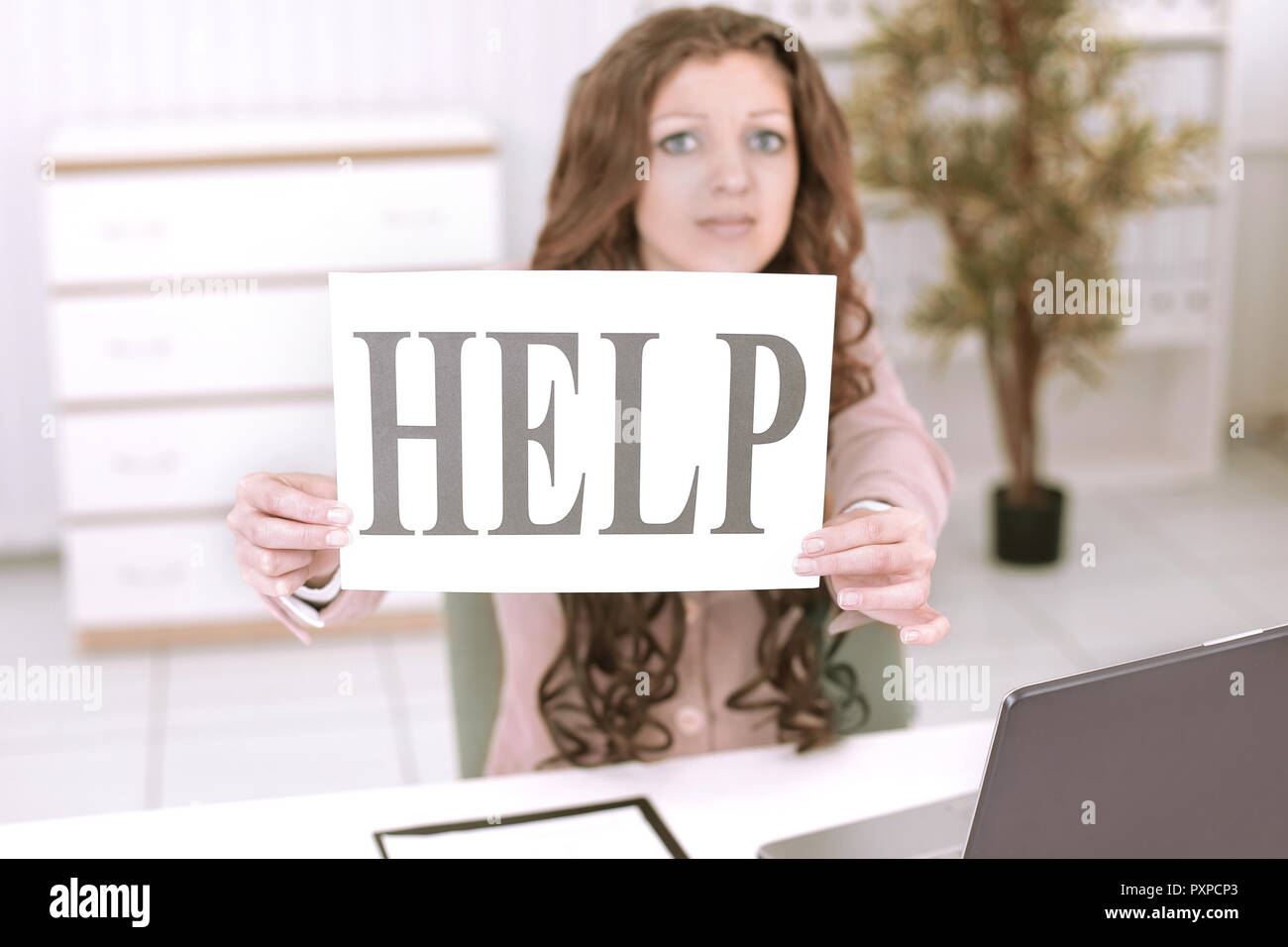 young business woman showing poster that says help Stock Photo - Alamy