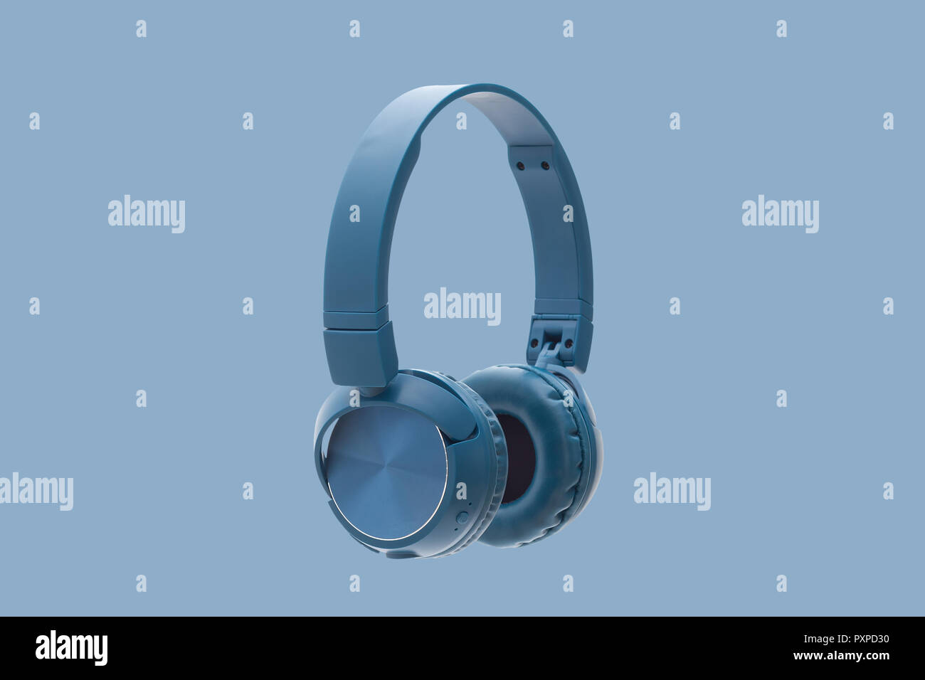 bluetooth blue headphone on blue background studio pack shot equipment ...