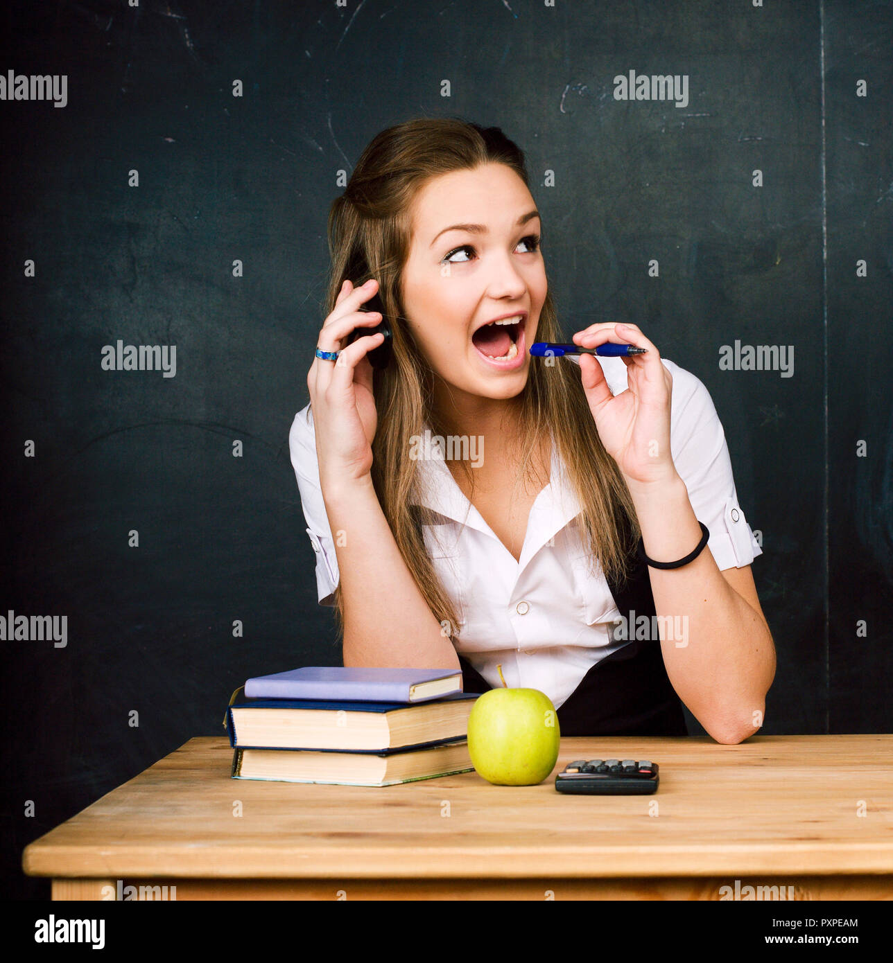 young pretty girl student in classroom at blackboard doing homework ...