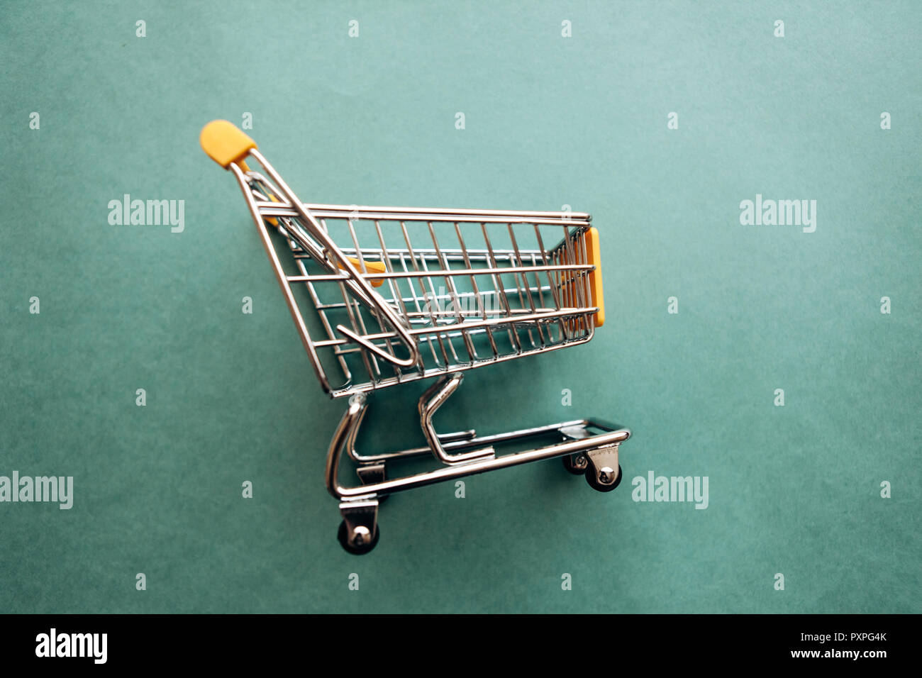 Empty cart for products and goods on a green background Stock Photo - Alamy