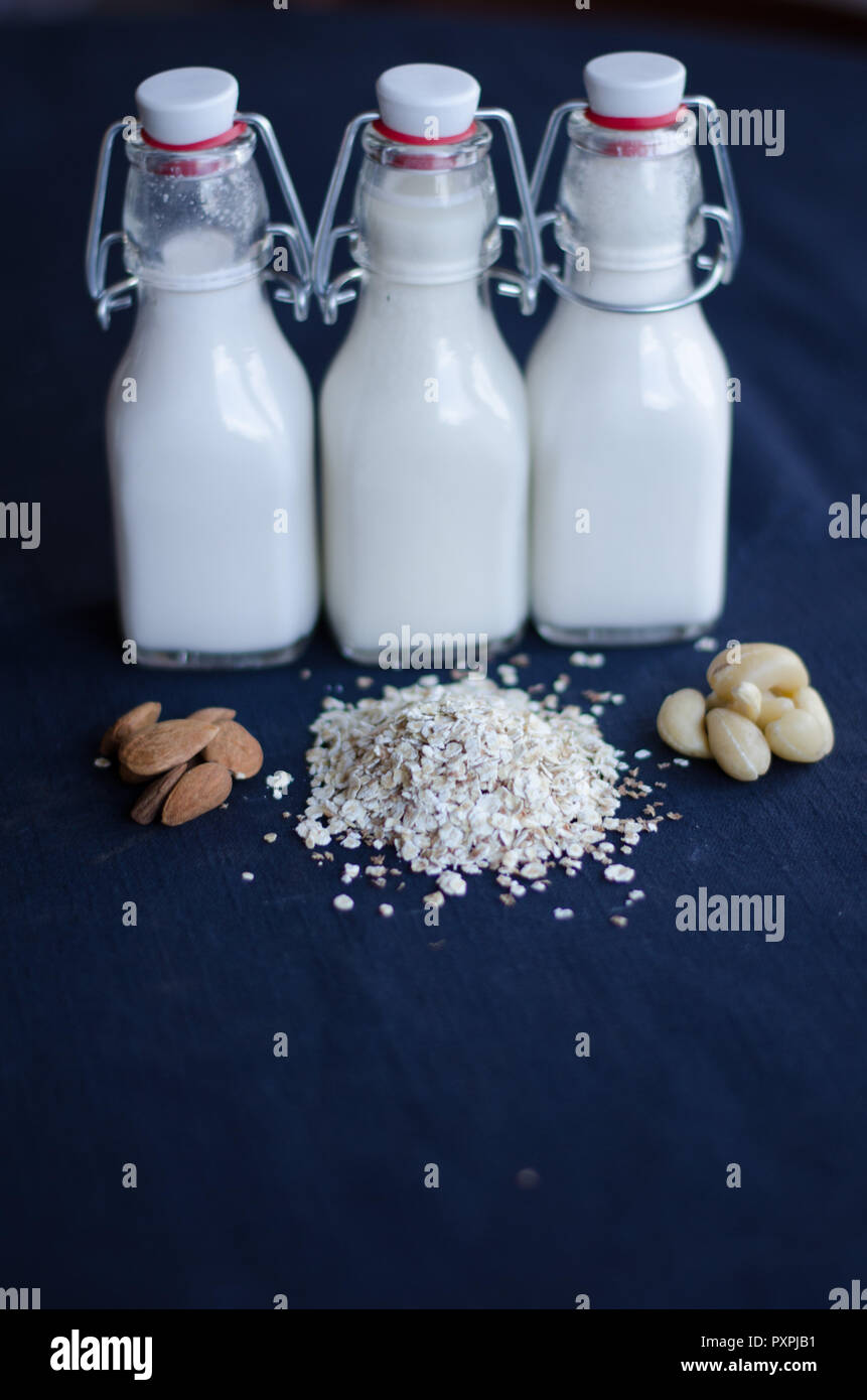 Almond milk, cashew nut milk and oat milk standing together with ...