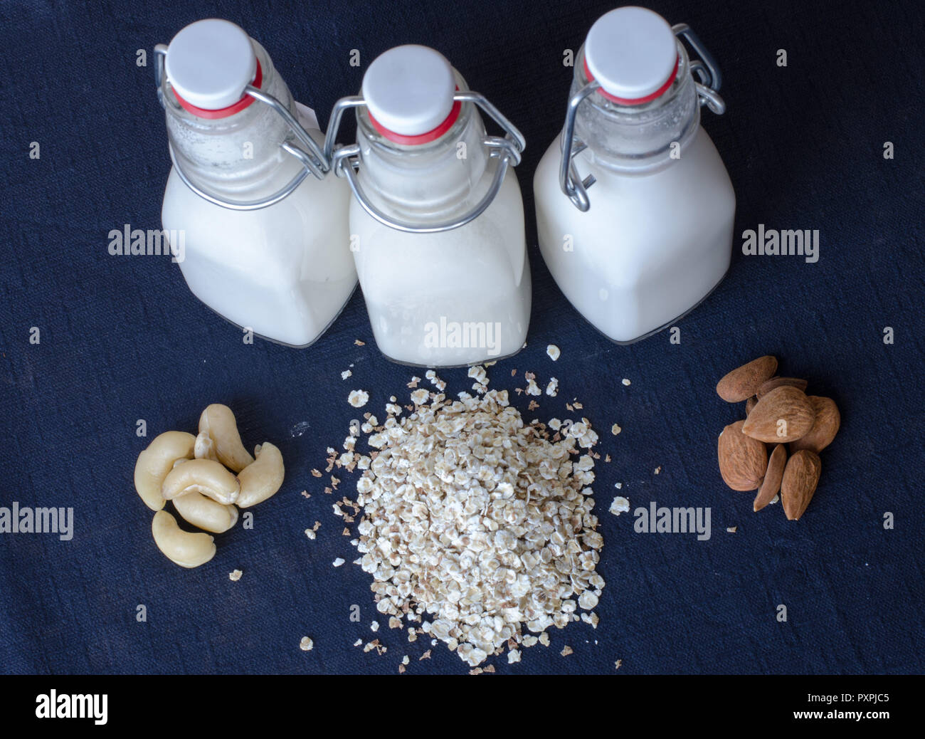 Almond milk, cashew nut milk and oat milk standing together with ...