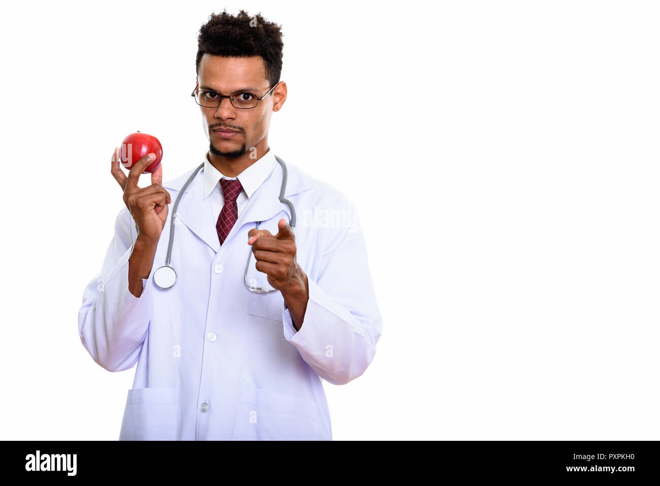Young African man doctor holding red apple while pointing at cam Stock ...