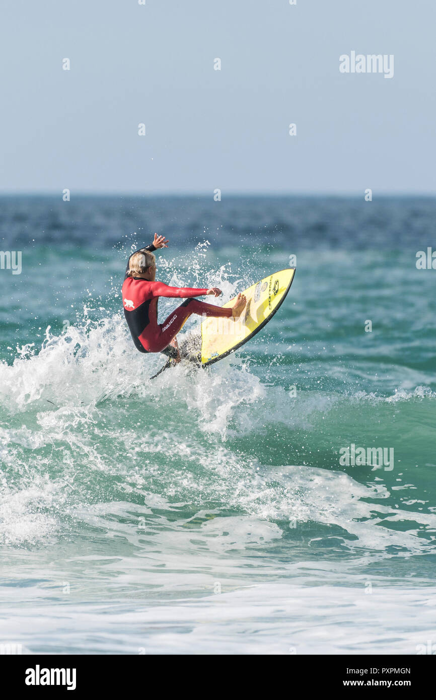 UK surfing - a young surfer riding a wave at Fistral Beach in Newquay ...