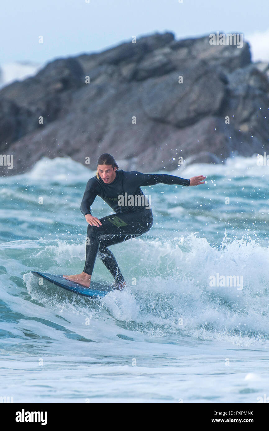 UK surfing - a surfer riding a wave at Fistral Beach in Newquay in ...