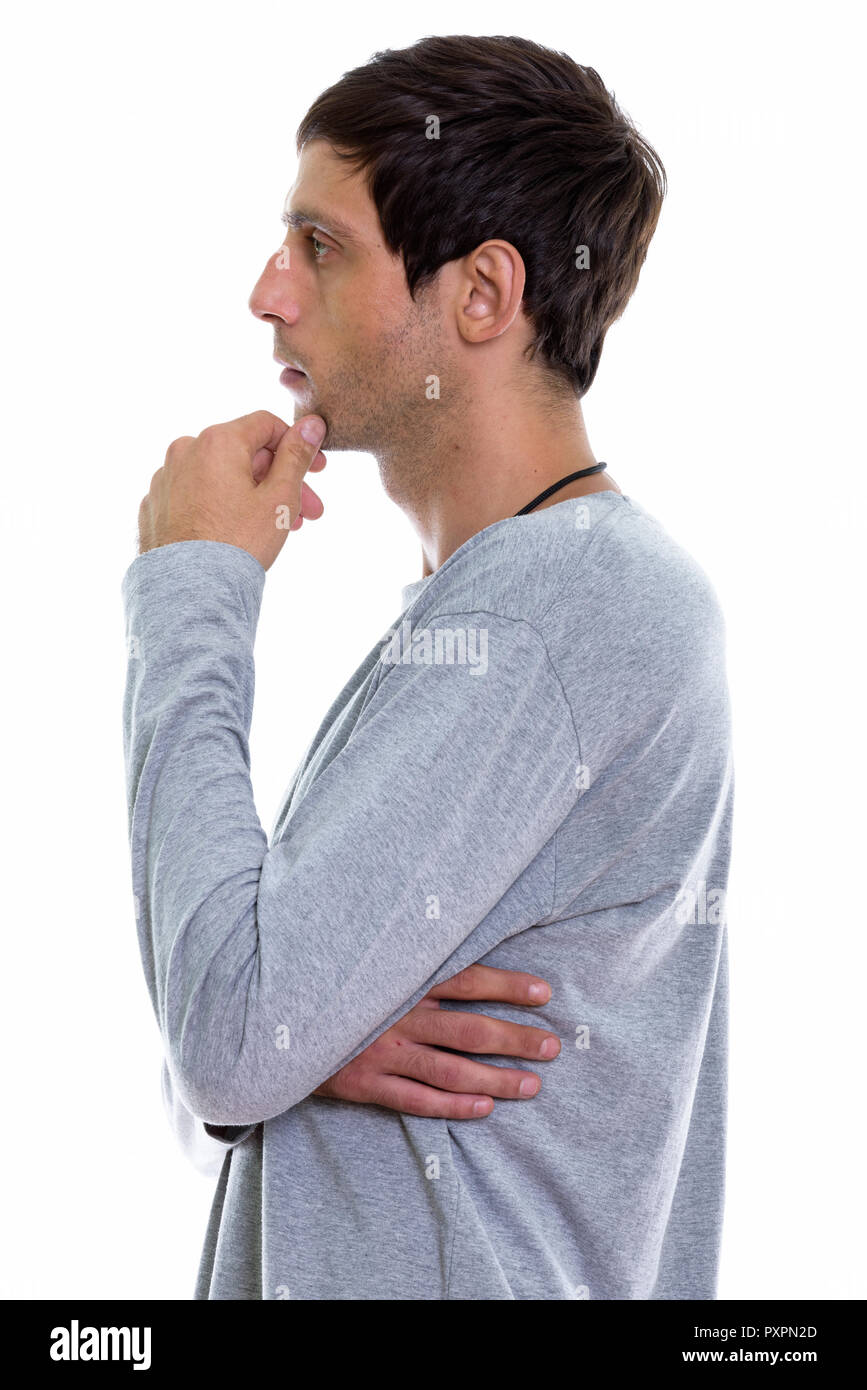Profile view of young handsome man thinking with hand on chin Stock ...