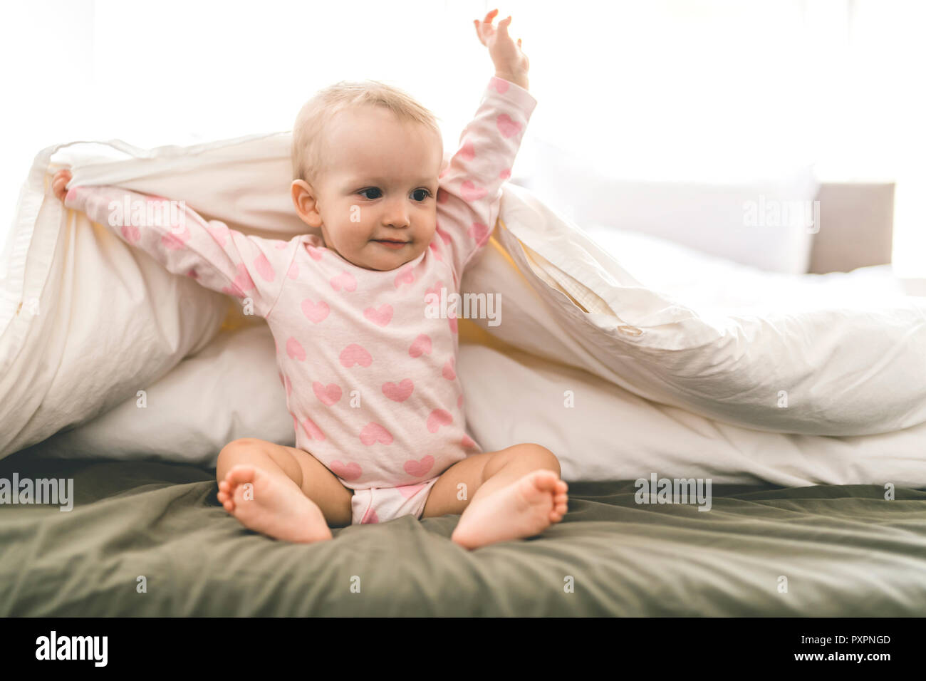 Adorable baby girl cover with white sheet wearing pink clothes Stock ...