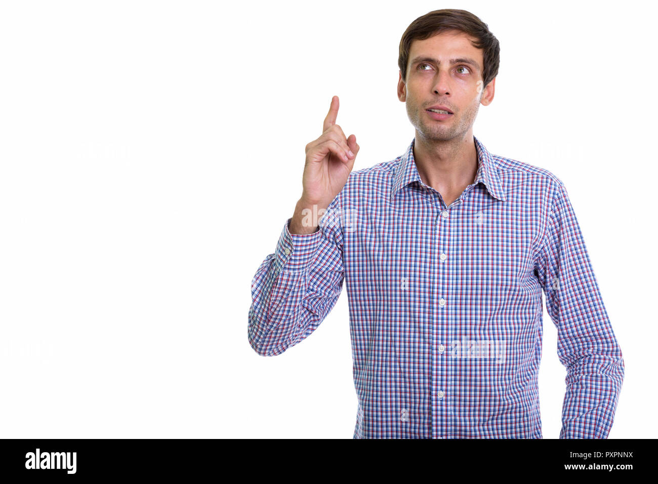 Studio shot of young handsome businessman thinking while pointin Stock ...