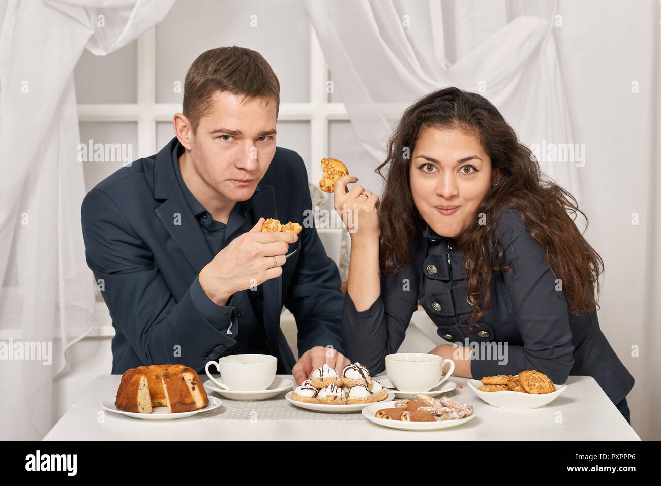 romantic couple drinking tea with cookies and talking Stock Photo - Alamy